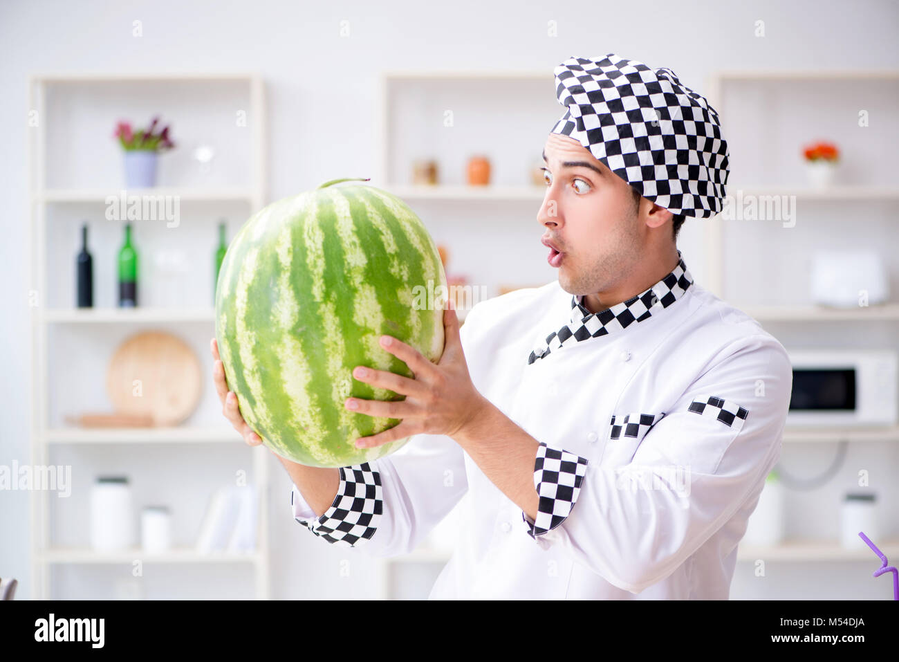 Male cook with watermelon in kitchen Stock Photo - Alamy