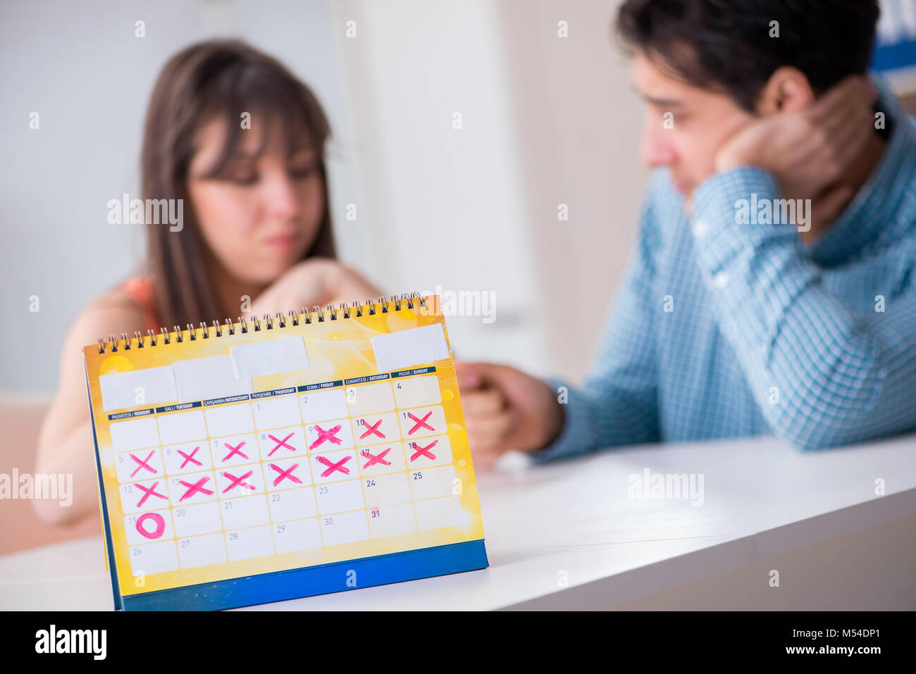 Young family in pregnancy planning concept with ovulation calendar ...