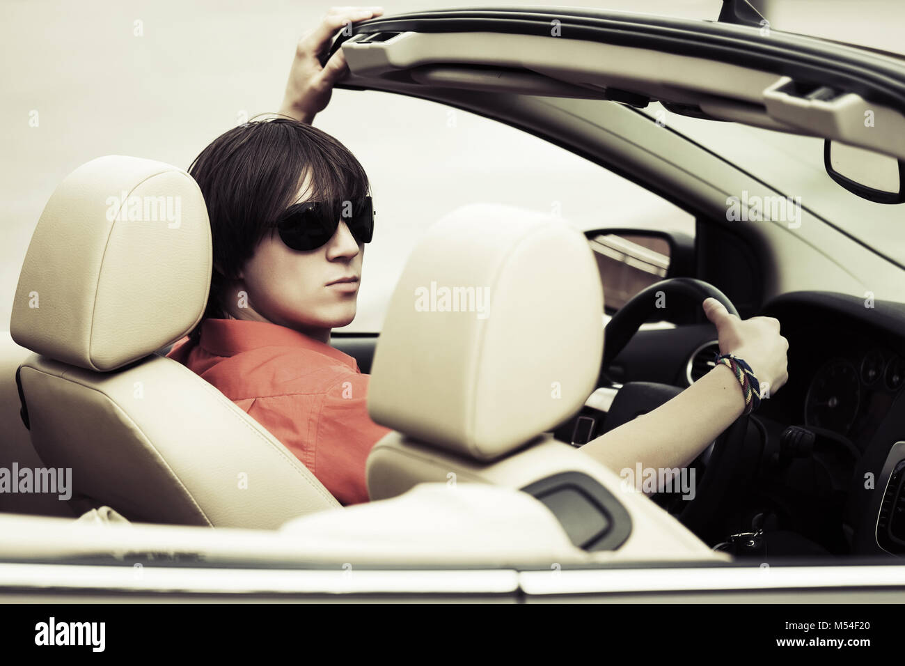 Young man driving a convertible car Stock Photo - Alamy