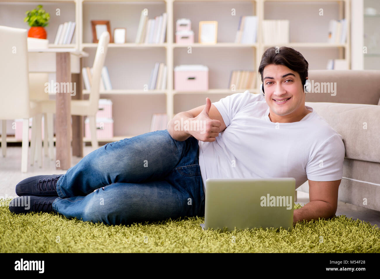 Man working on laptop at home on carpet floor Stock Photo - Alamy