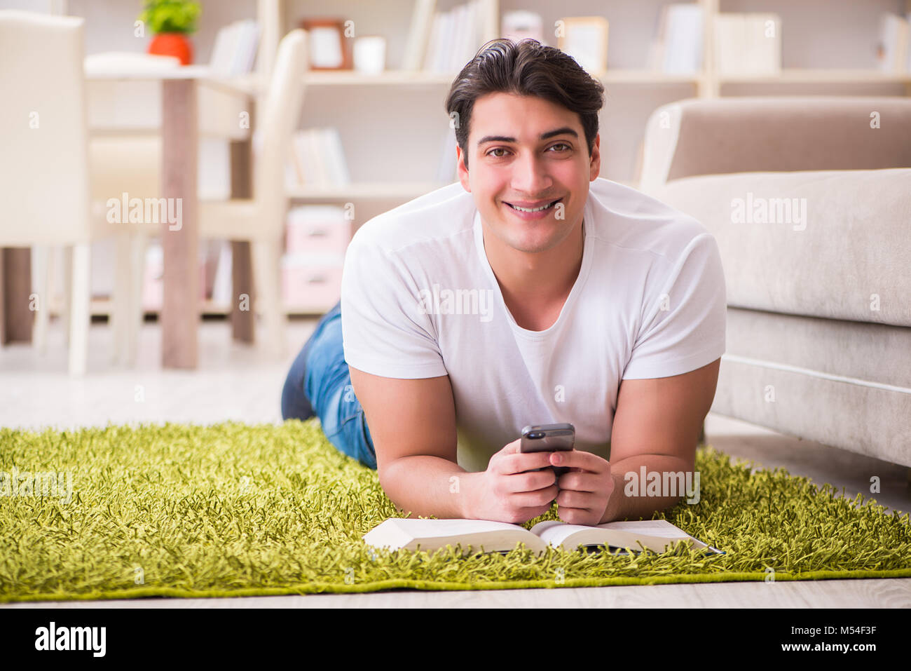 Man reading book at home on floor Stock Photo - Alamy