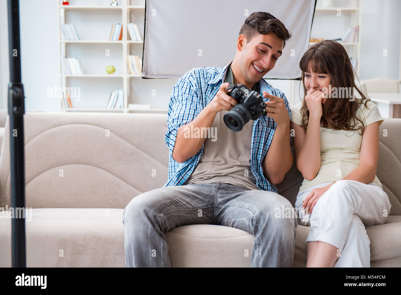 Young photographer working in photo studio Stock Photo - Alamy
