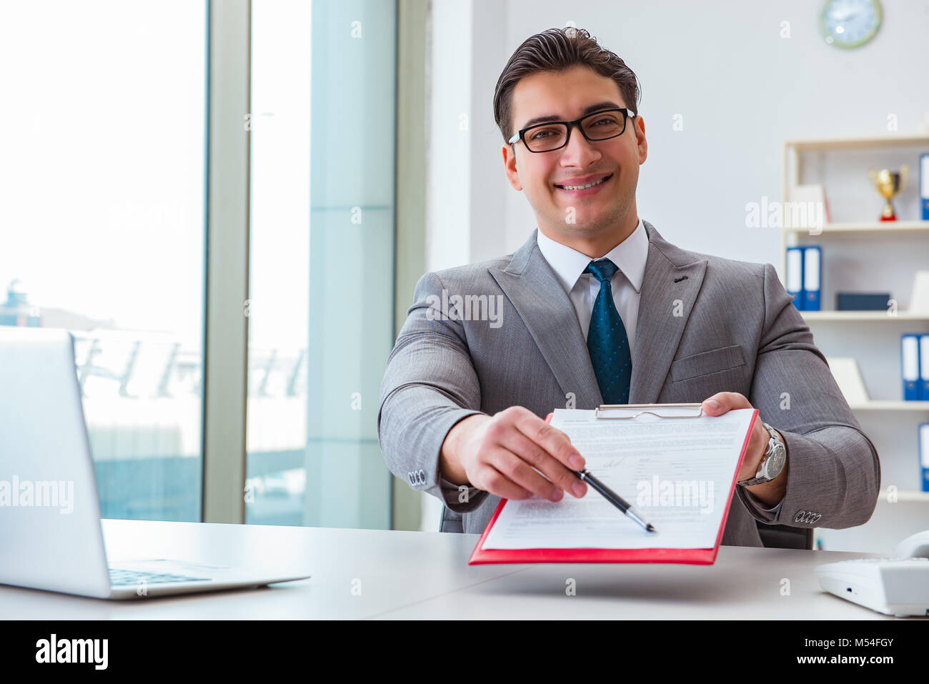 Businessman signing business documents in office Stock Photo - Alamy