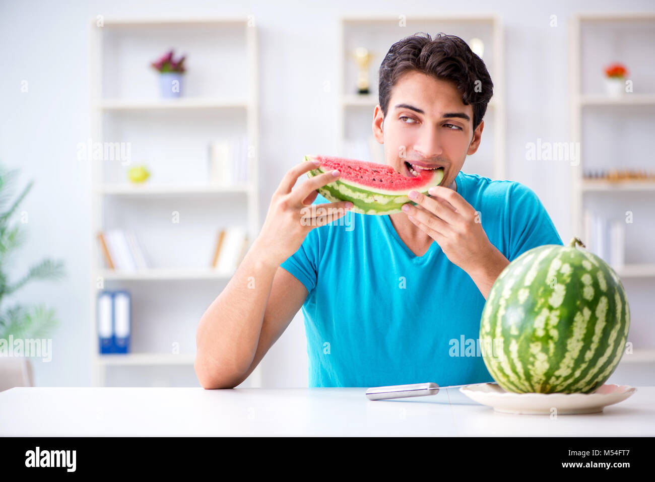 Man eating watermelon at home Stock Photo - Alamy