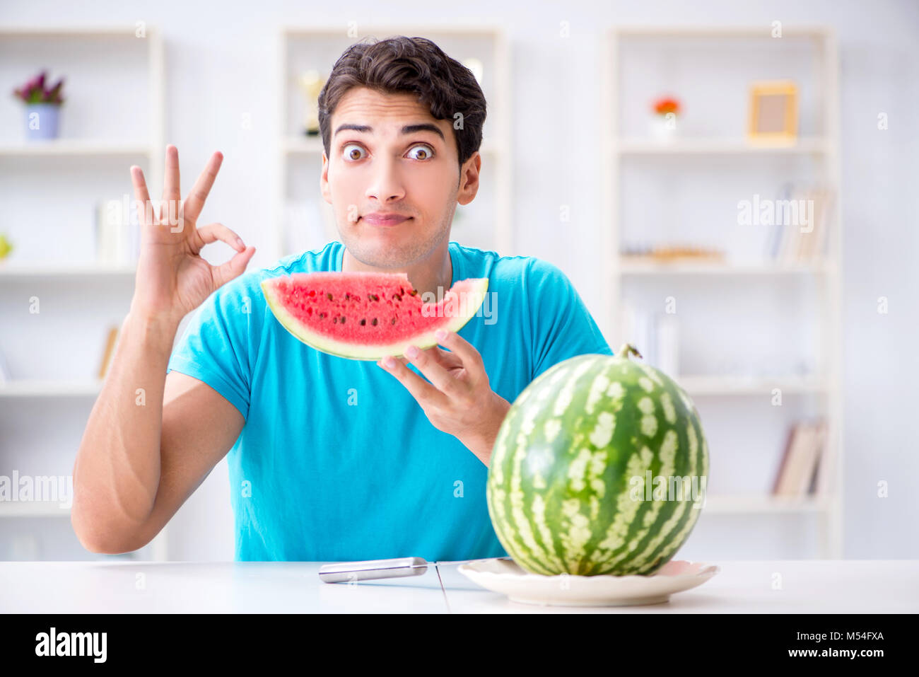 Man eating watermelon at home Stock Photo - Alamy