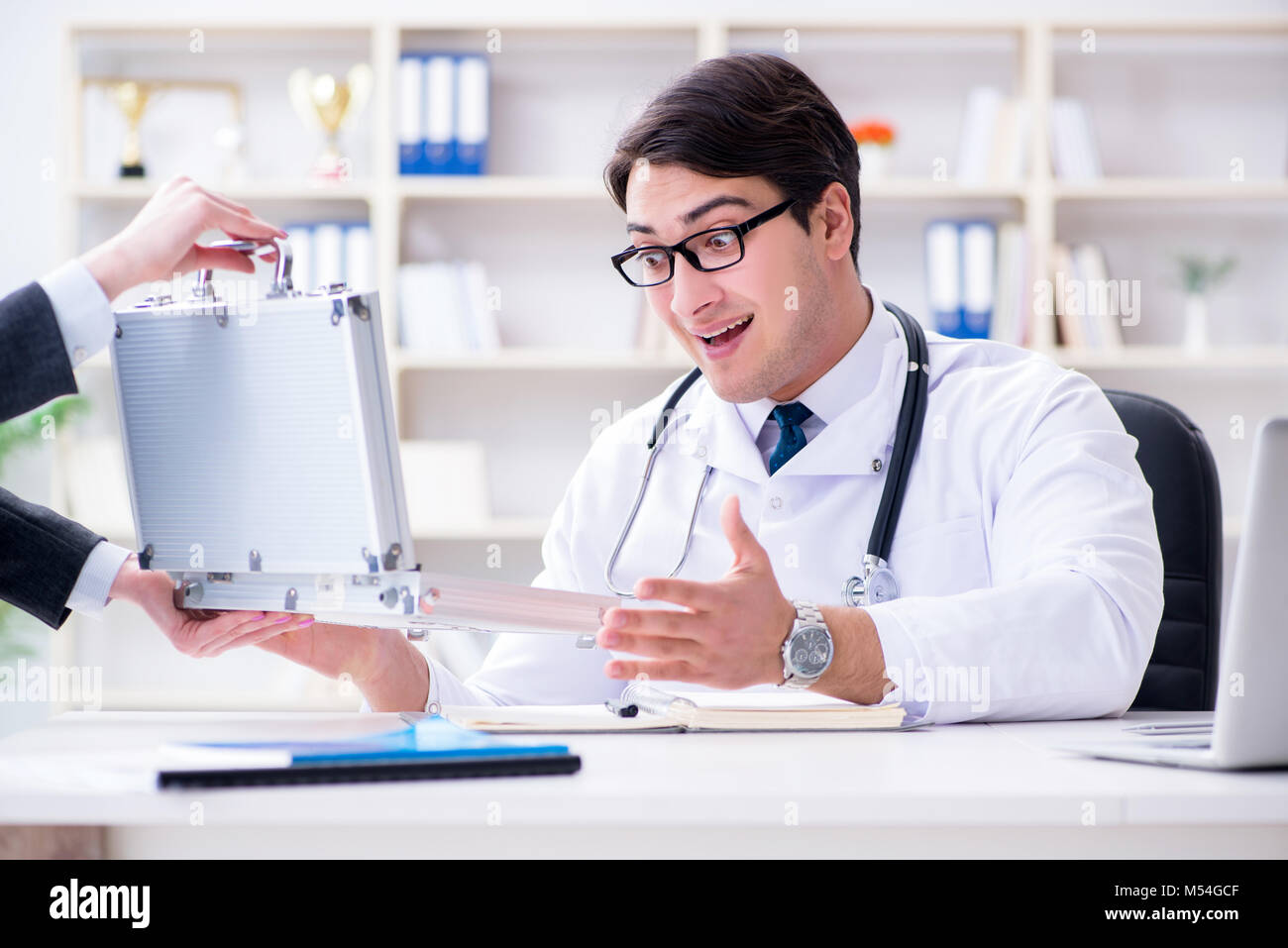 Young doctor in medical insurance fraud concept Stock Photo - Alamy