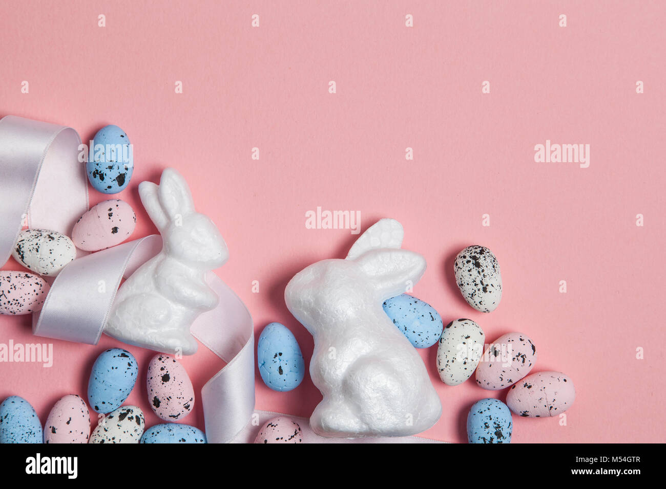 Pastel pink easter holiday background with eggs and easter bunnies ...