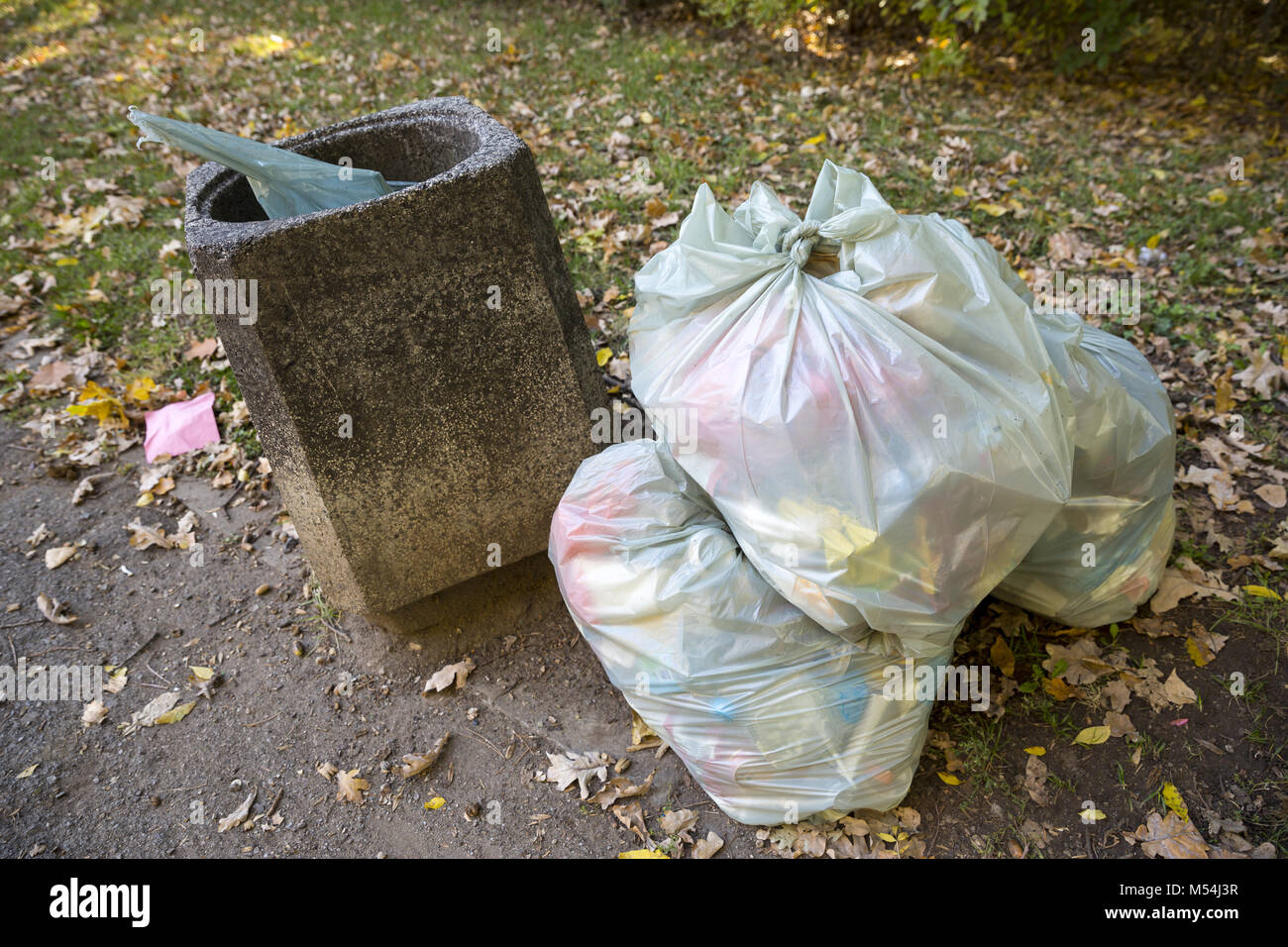 Garbage bags in the park near bin Stock Photo - Alamy