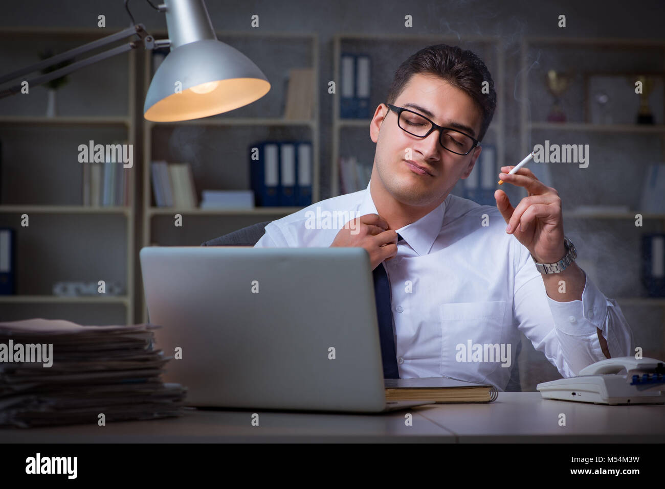 Businessman under stress smoking in office Stock Photo - Alamy