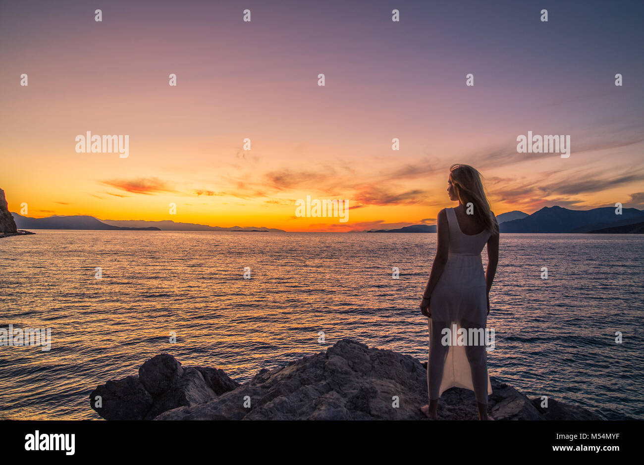 A beautiful girl watches the sunset Stock Photo - Alamy