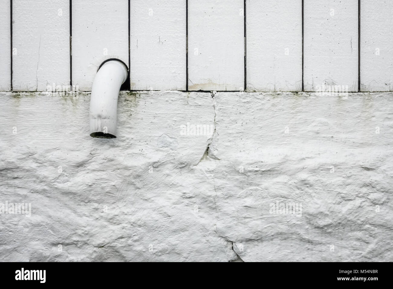 Small pipe tip sticking out of a white wooden fence Stock Photo - Alamy
