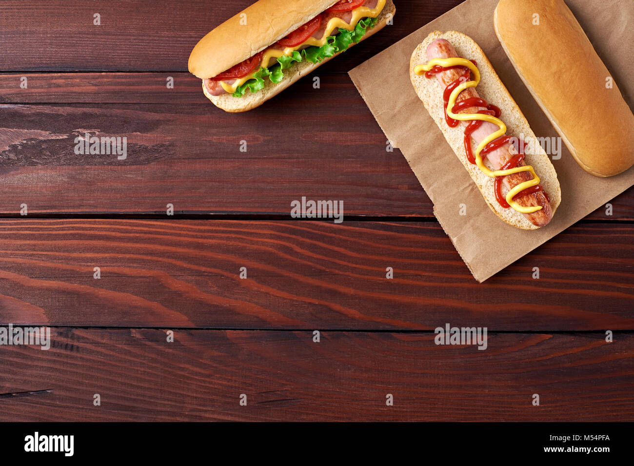 Two tasty Hot Dogs laying on craft paper with sausage on wooden ...