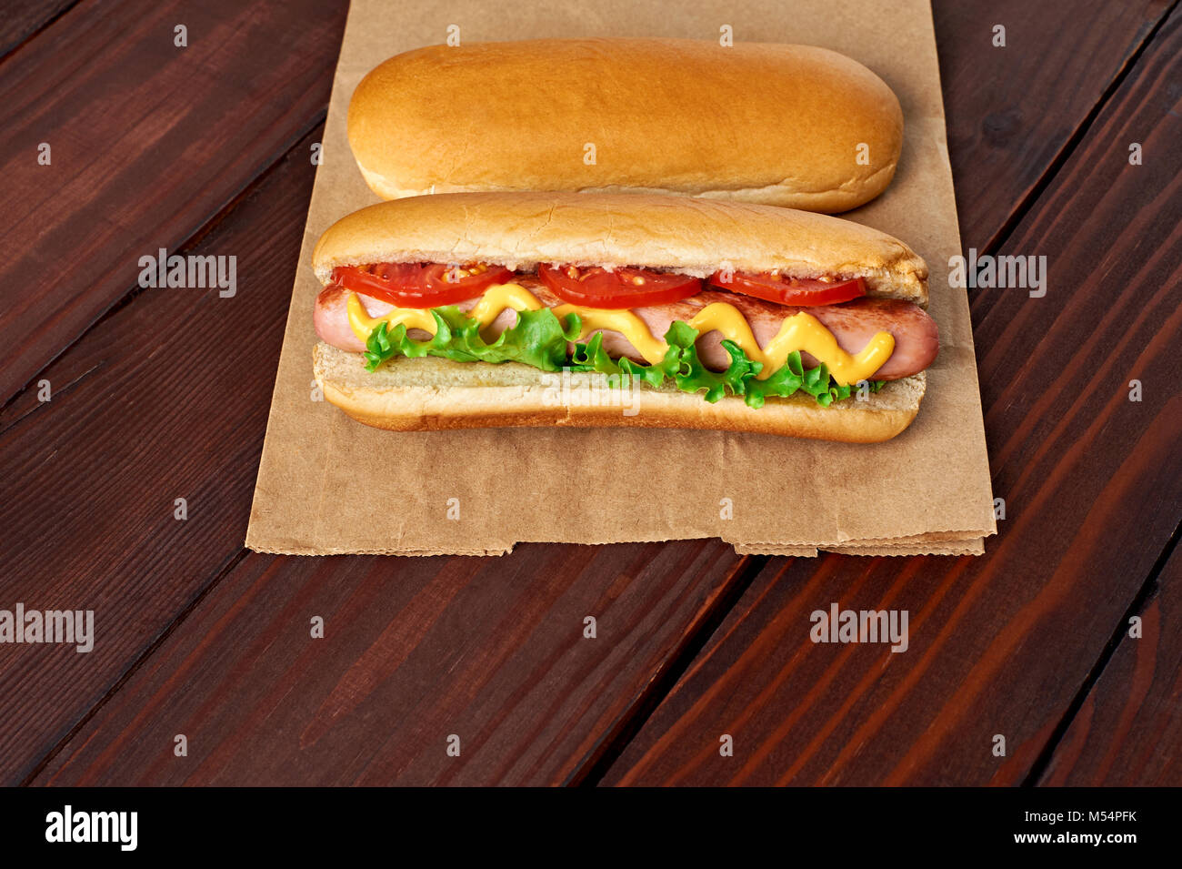 Two tasty Hot Dogs laying on craft paper with sausage on wooden ...
