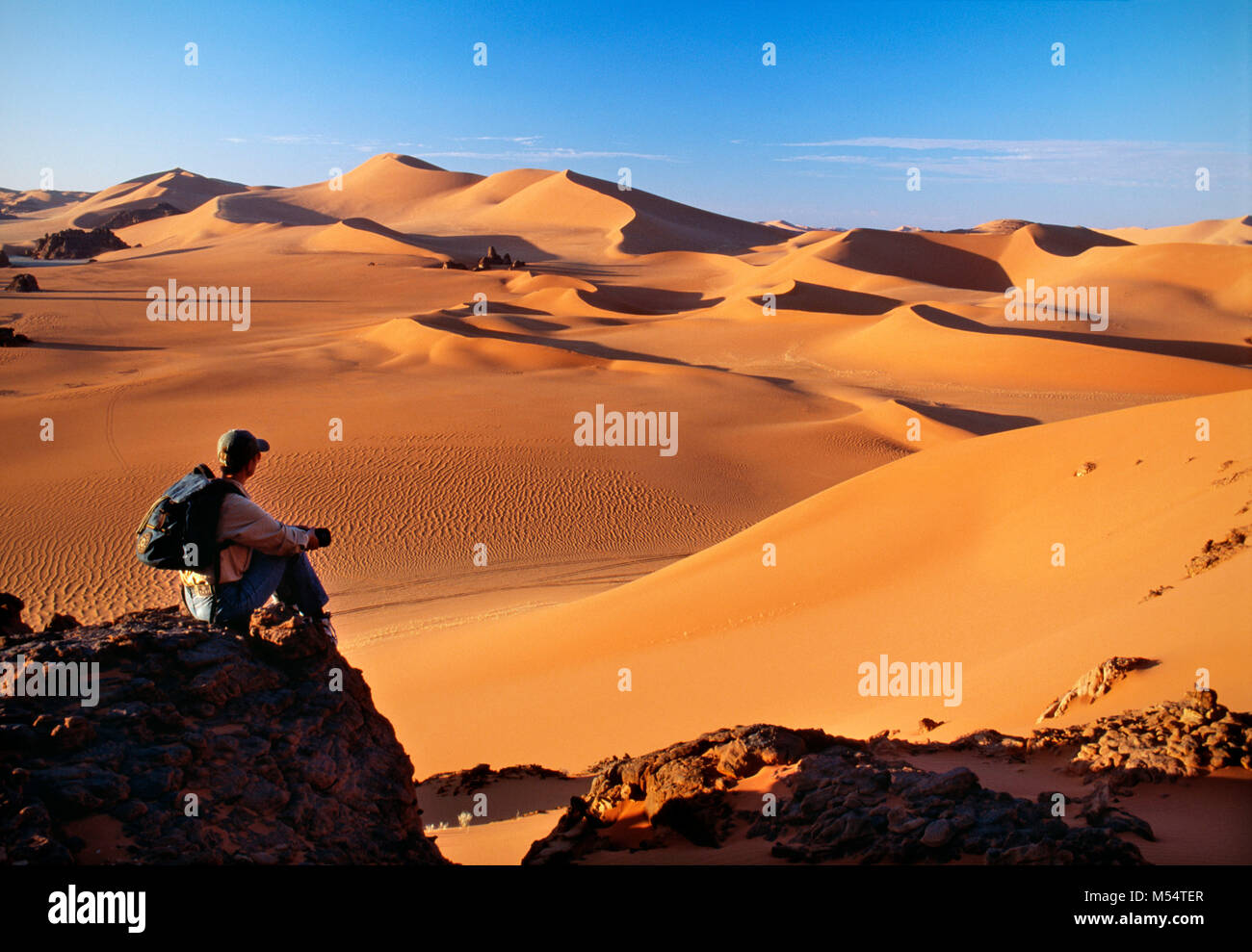 Algeria. Near Djanet. Sahara desert. Woman with backpack sitting on ...