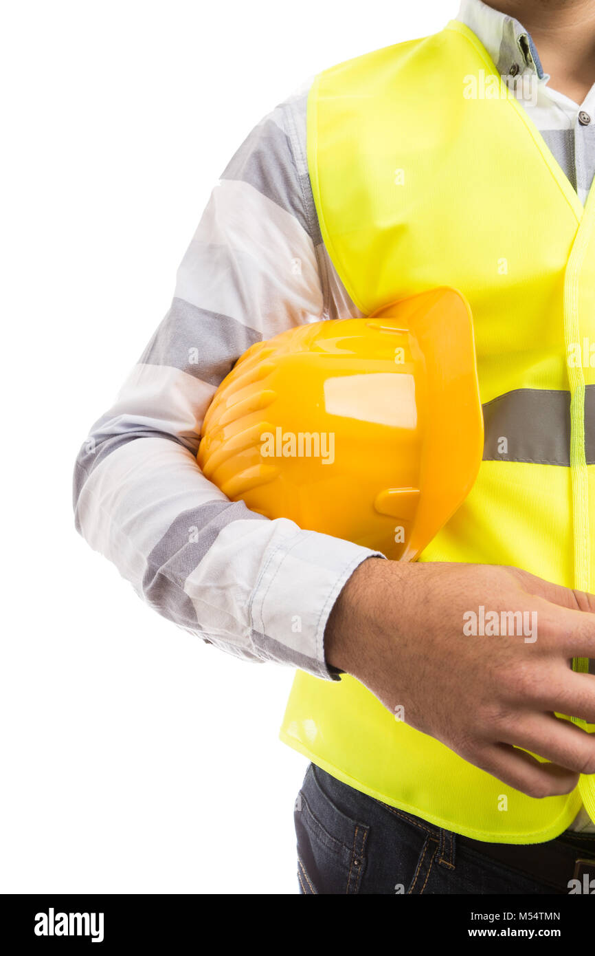 Builder holding a yellow hardhat underarm or under armpit as a ...