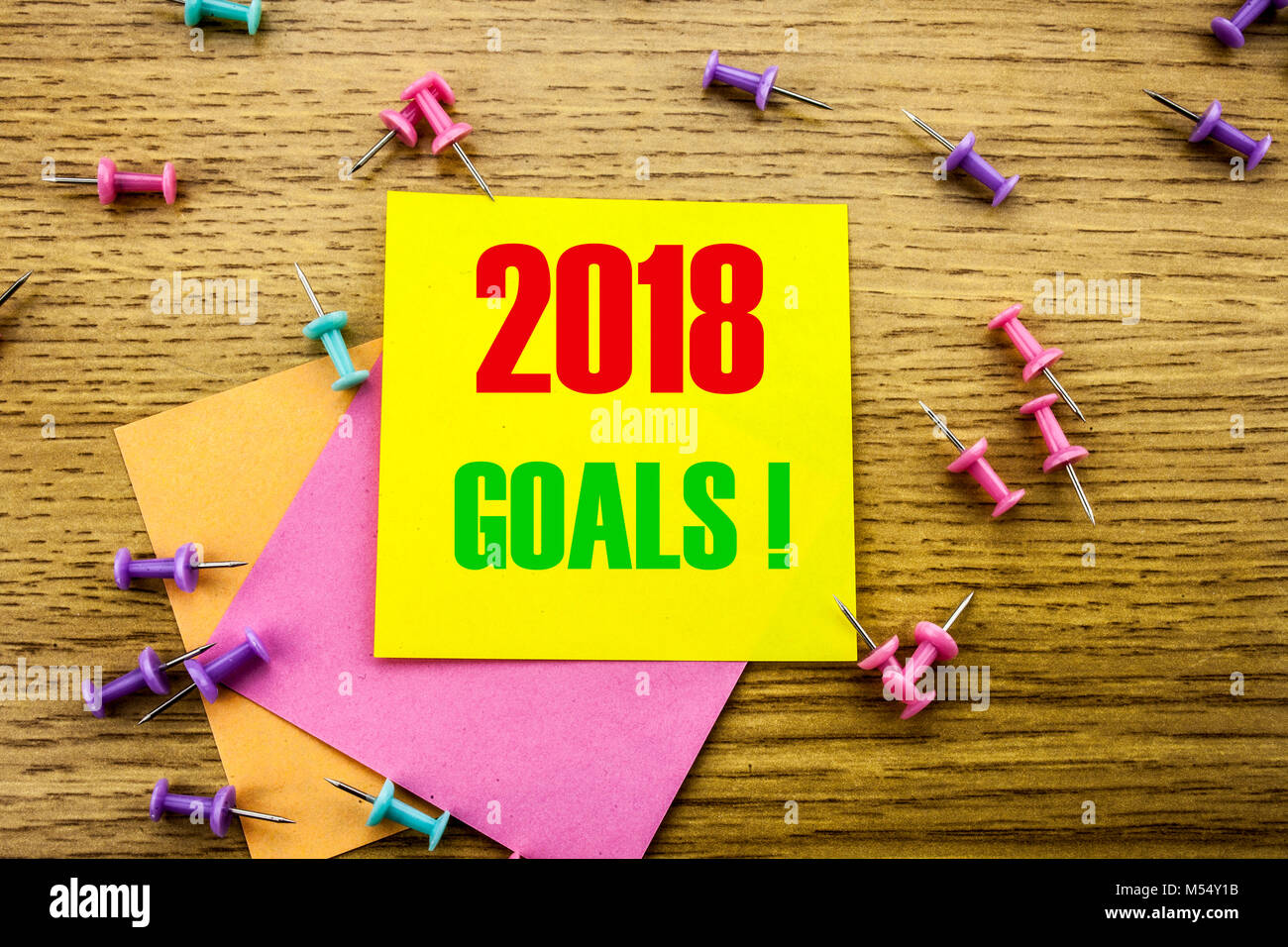 2018 goals on yellow sticky note, on wooden background. New Year ...