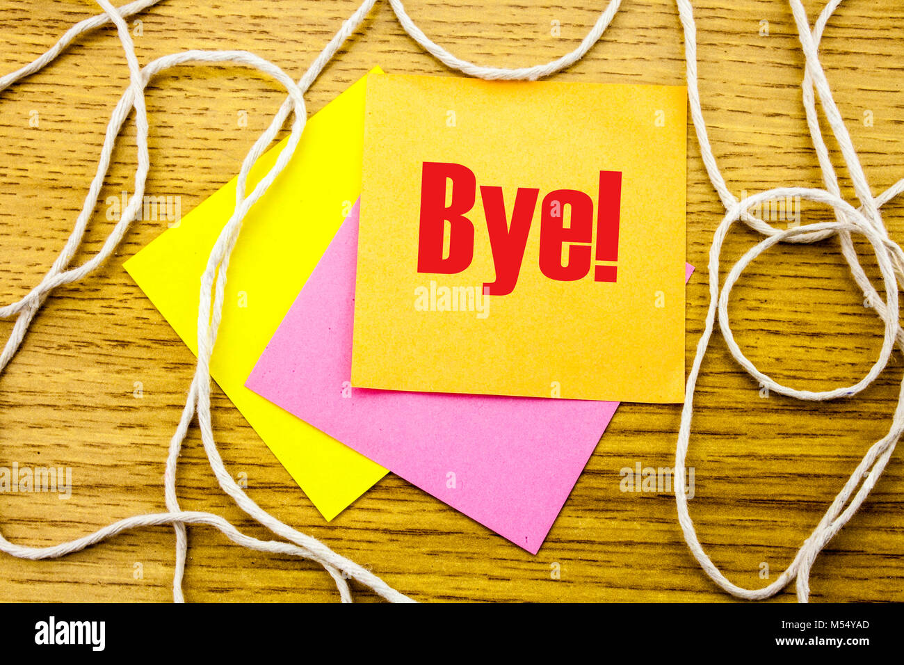 Bye word on yellow sticky note in wooden background. Bussines concept ...