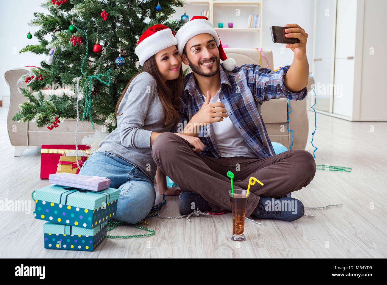 The young pair taking selfies during christmas Stock Photo - Alamy