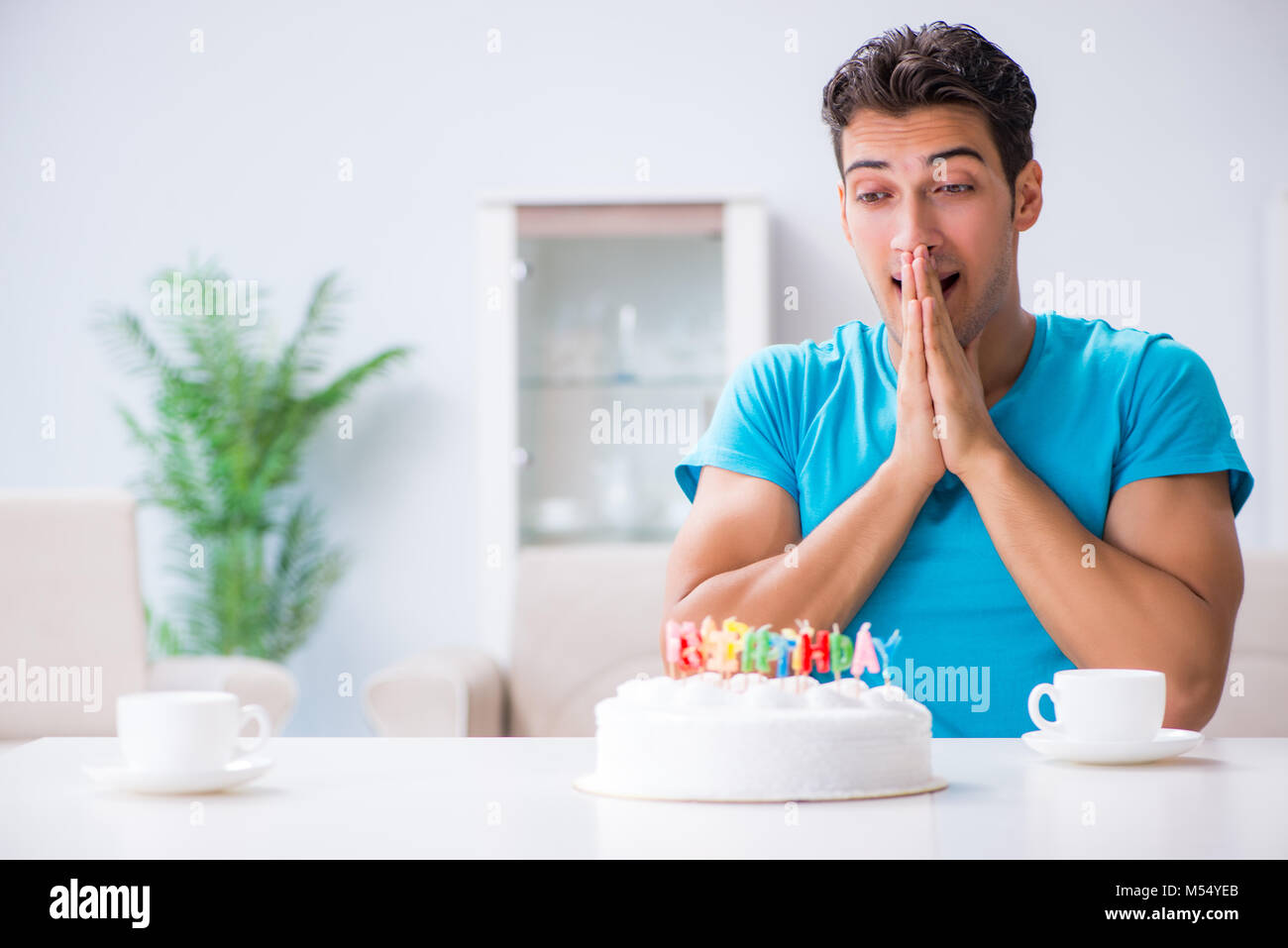 The young man celebrating birthday alone at home Stock Photo - Alamy