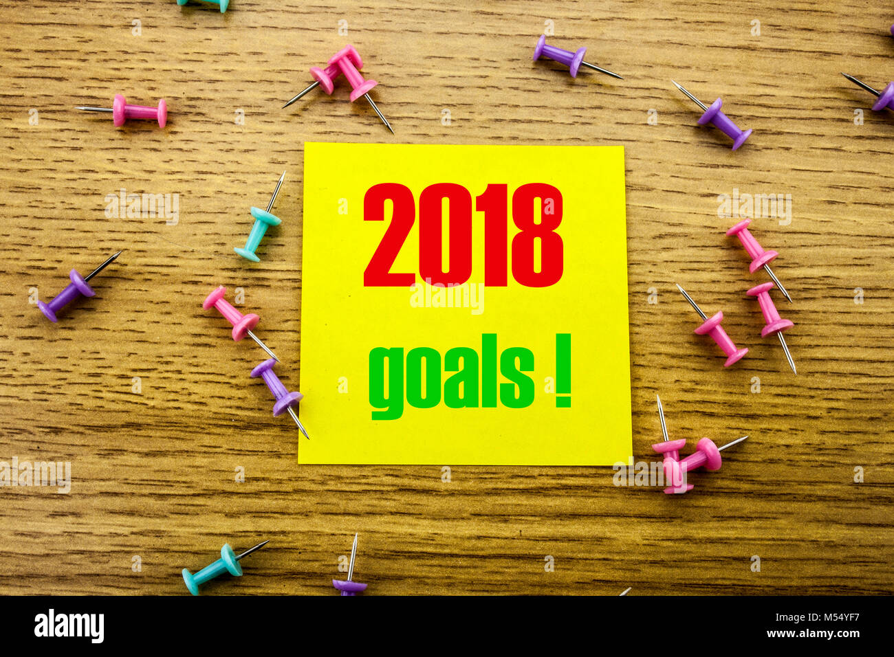 2018 goals on yellow sticky note, on wooden background. New Year ...