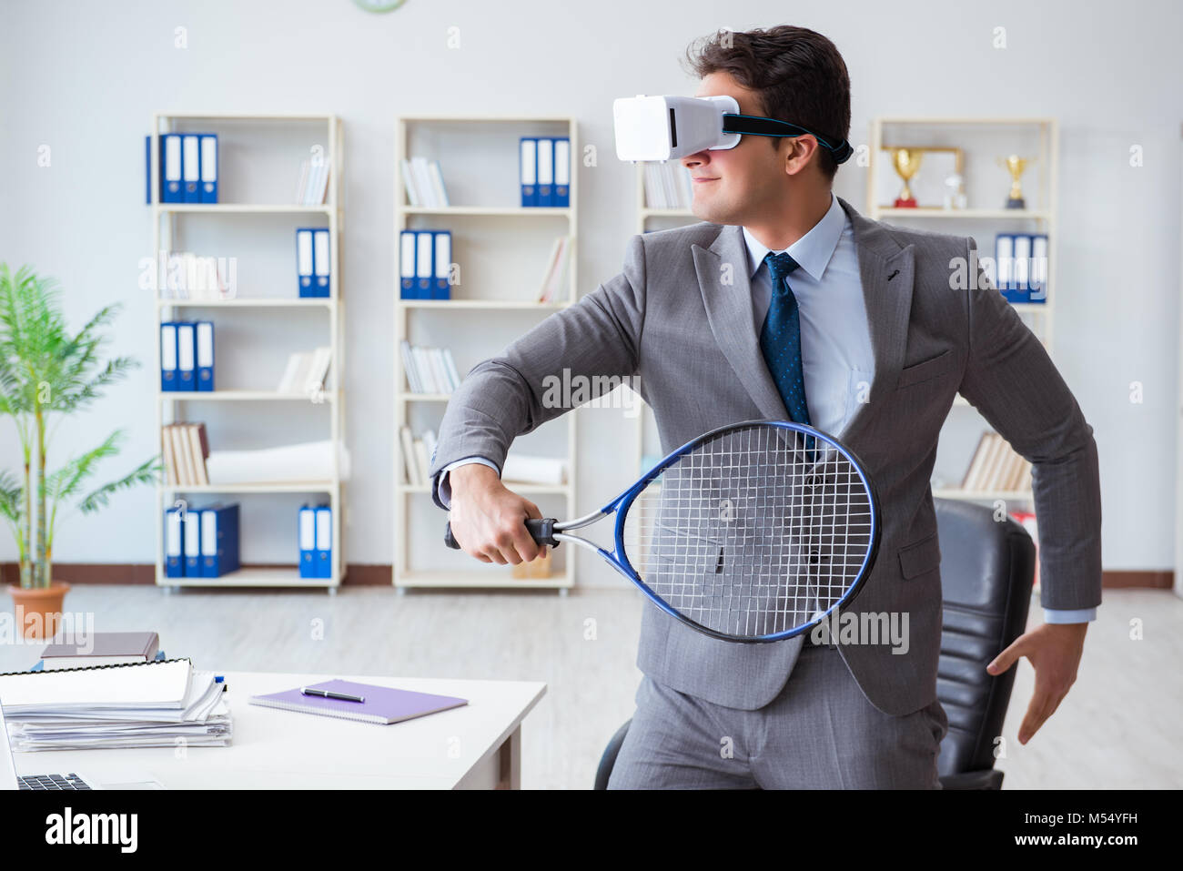Businessman playing virtual reality tennis in office with VR gog Stock ...