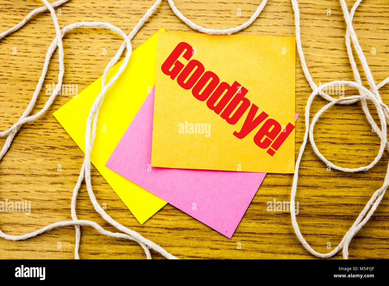 Goodbye word on yellow sticky note in wooden background. Bussines ...