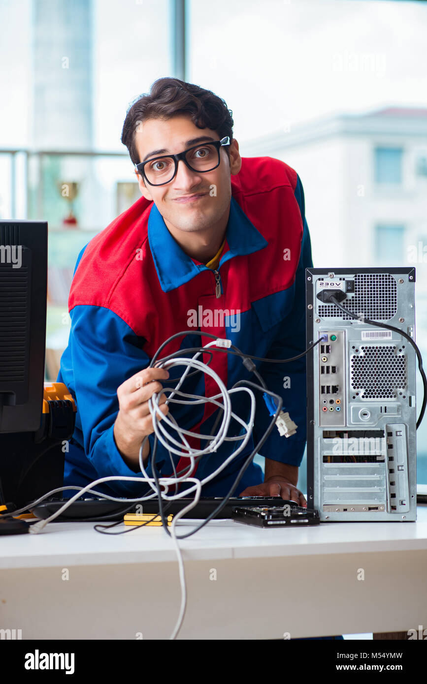 The computer repairman working on repairing computer in it workshop ...