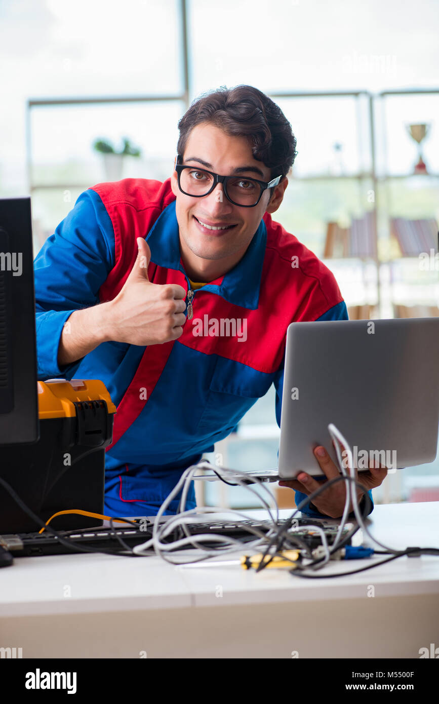 The computer repairman working on repairing computer in it workshop ...