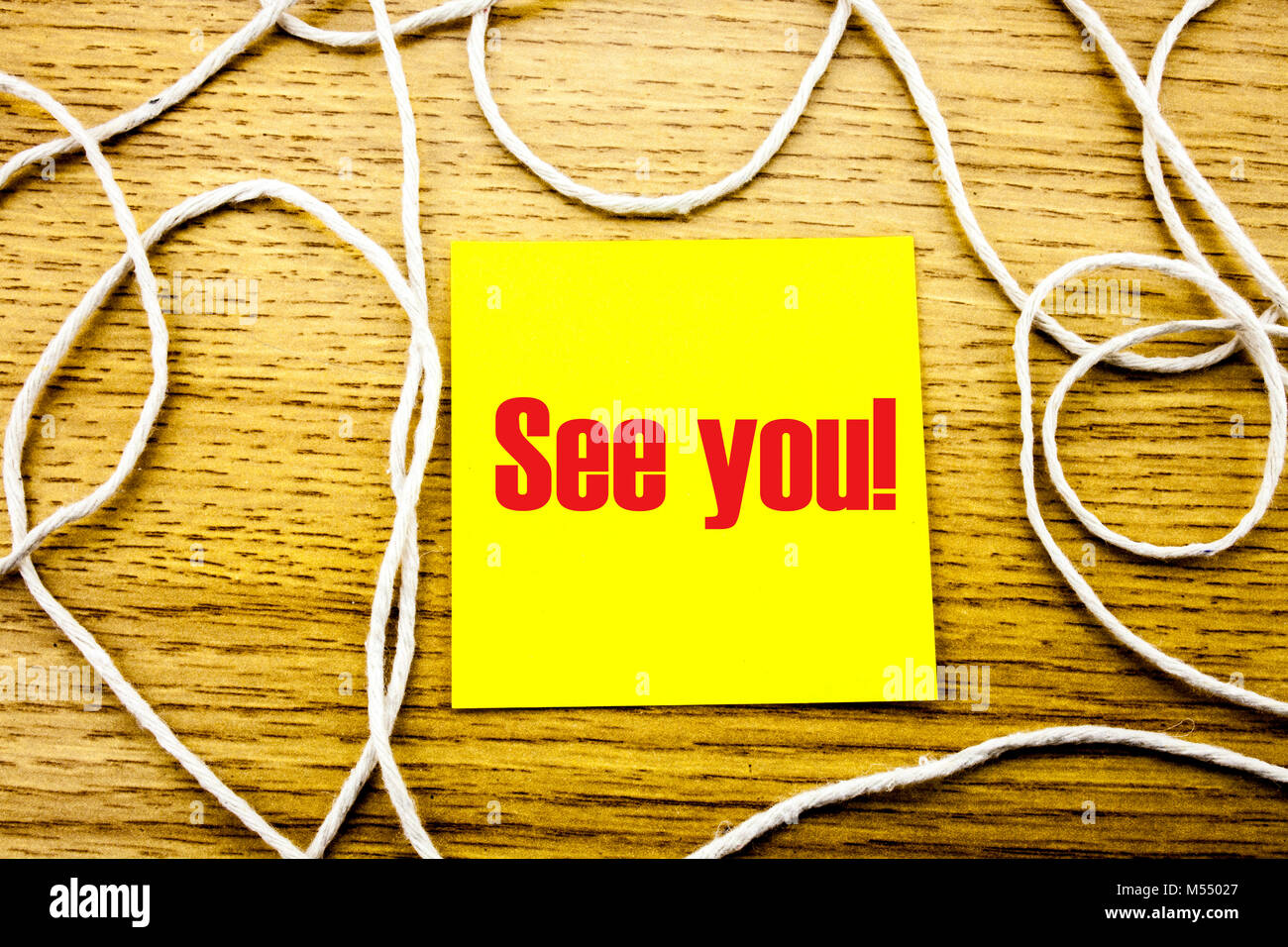 See you - word on yellow sticky note in wooden background. Bussines ...