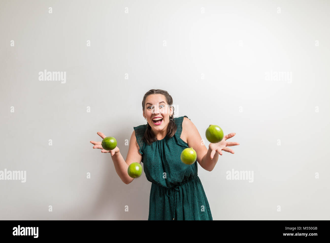 Laughing girl on a white background throwing fruits Stock Photo - Alamy