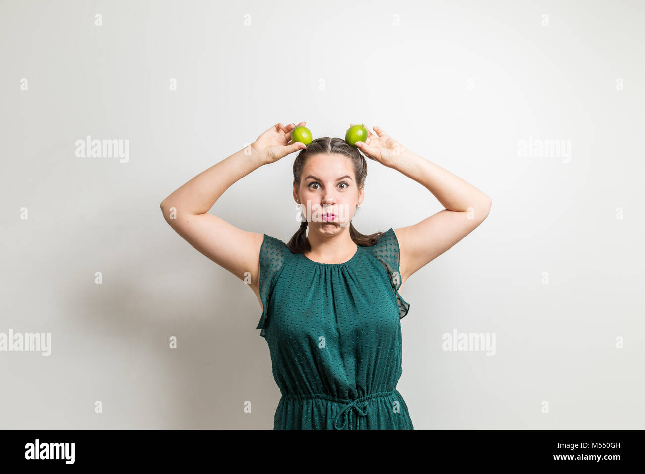 Laughing girl poses with lime fruits over white background Stock Photo ...