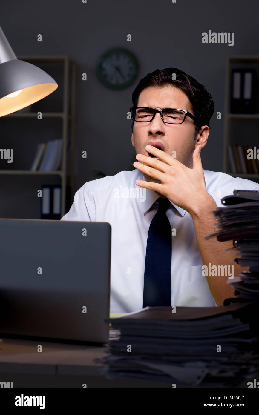 Young businessman working overtime late in office Stock Photo - Alamy