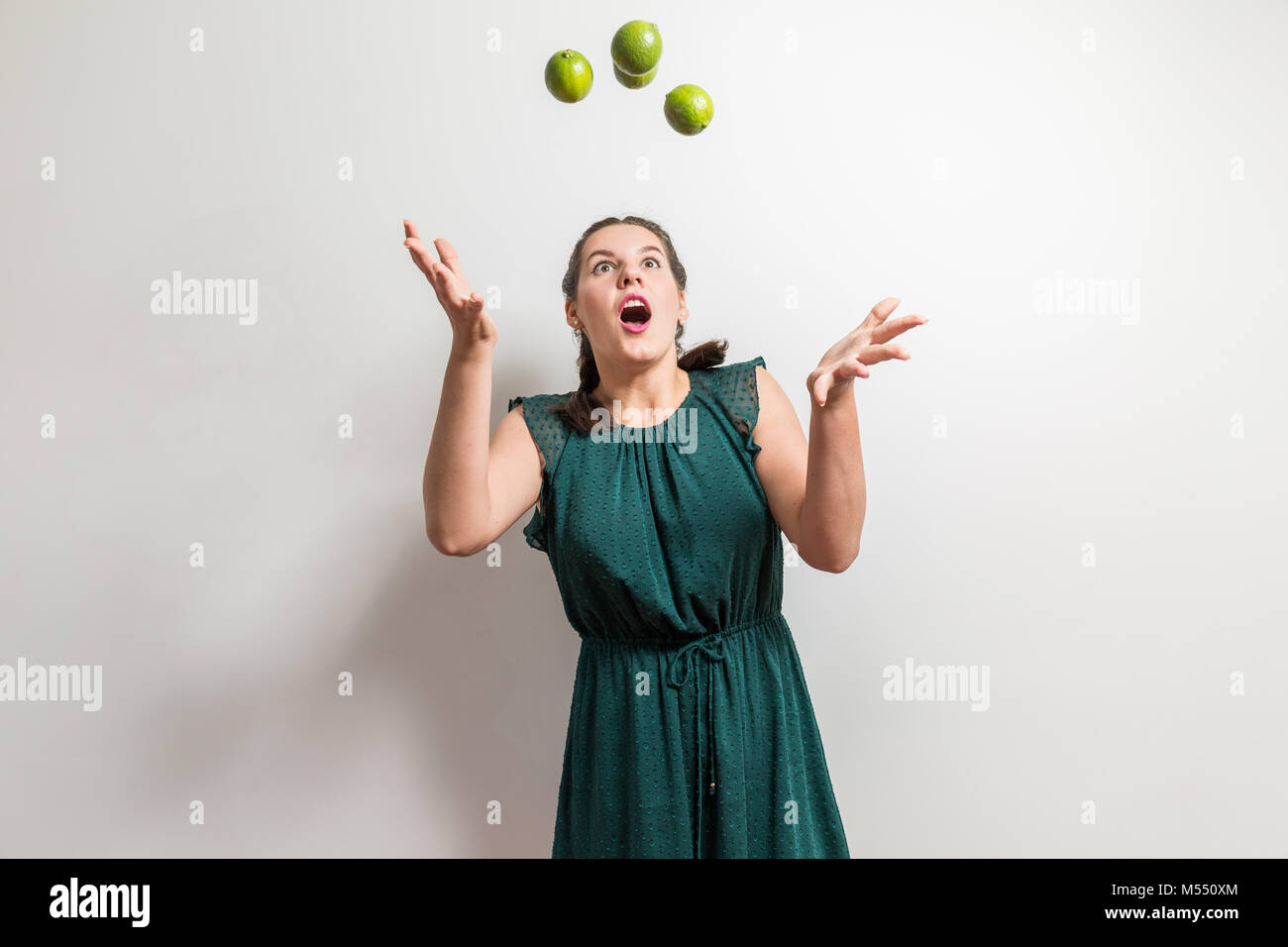 Young woman is in shock that lime fruits are falling Stock Photo - Alamy