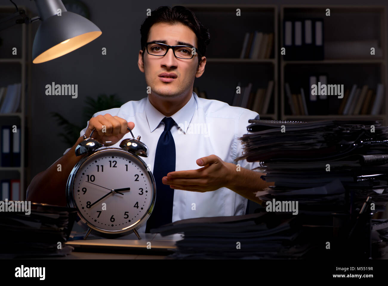 Young businessman working overtime late in office Stock Photo - Alamy