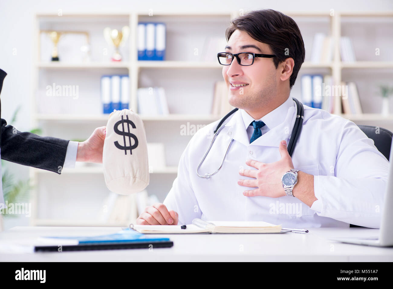 Young doctor in medical insurance fraud concept Stock Photo - Alamy