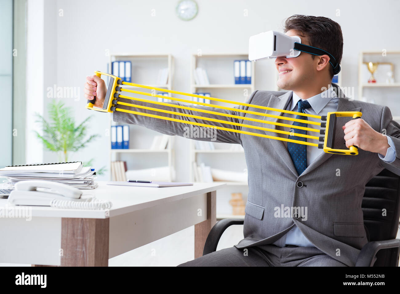 Businessman exercising with elastic expander wearing VR glasses Stock ...