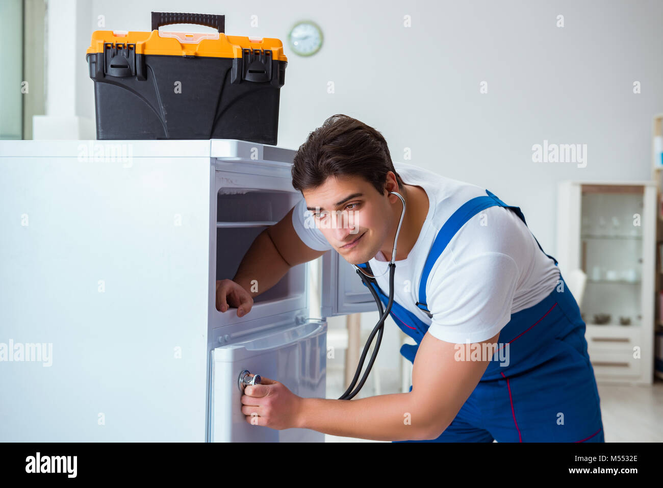 Repairman contractor repairing fridge in DIY concept Stock Photo - Alamy