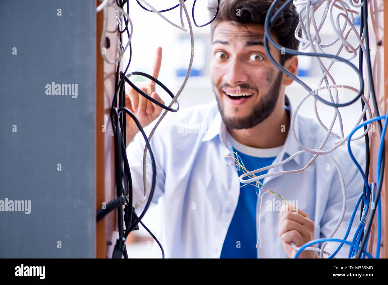 Electrician trying to untangle wires in repair concept Stock Photo - Alamy