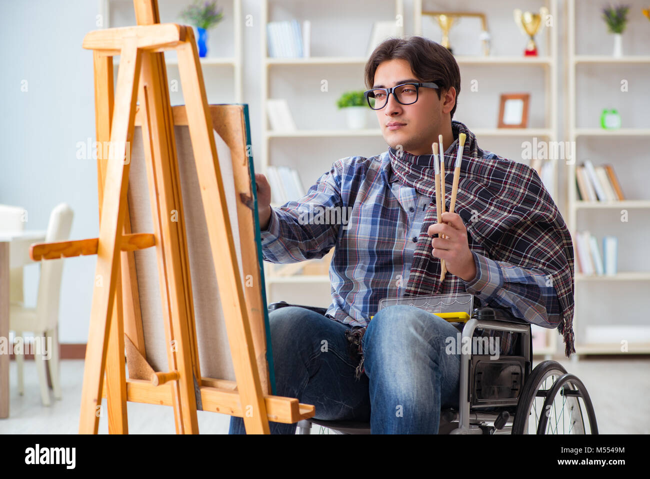 Disabled artist painting picture in studio Stock Photo - Alamy