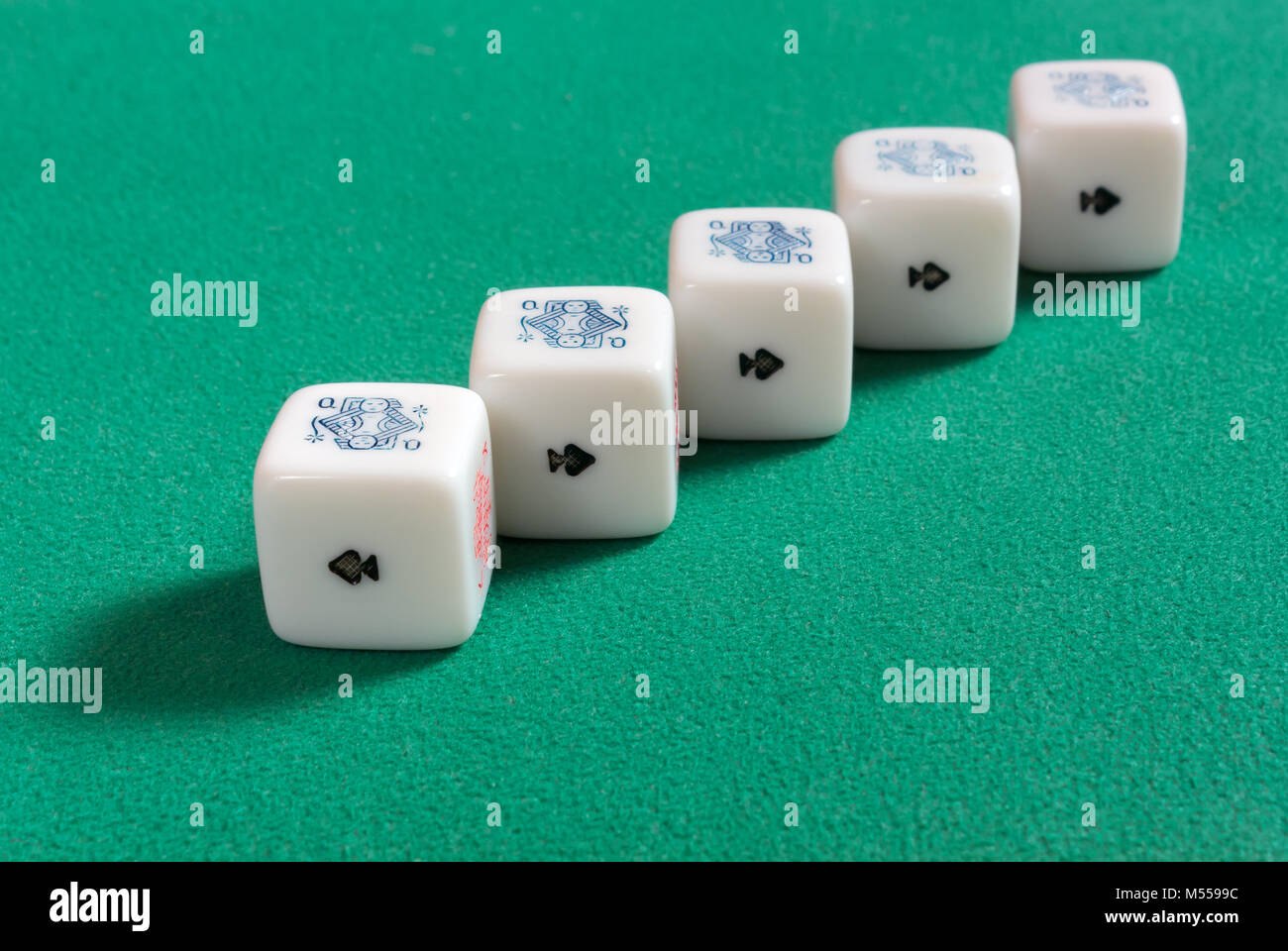 Perspective view of poker dice on a green table with a five of a kind ...