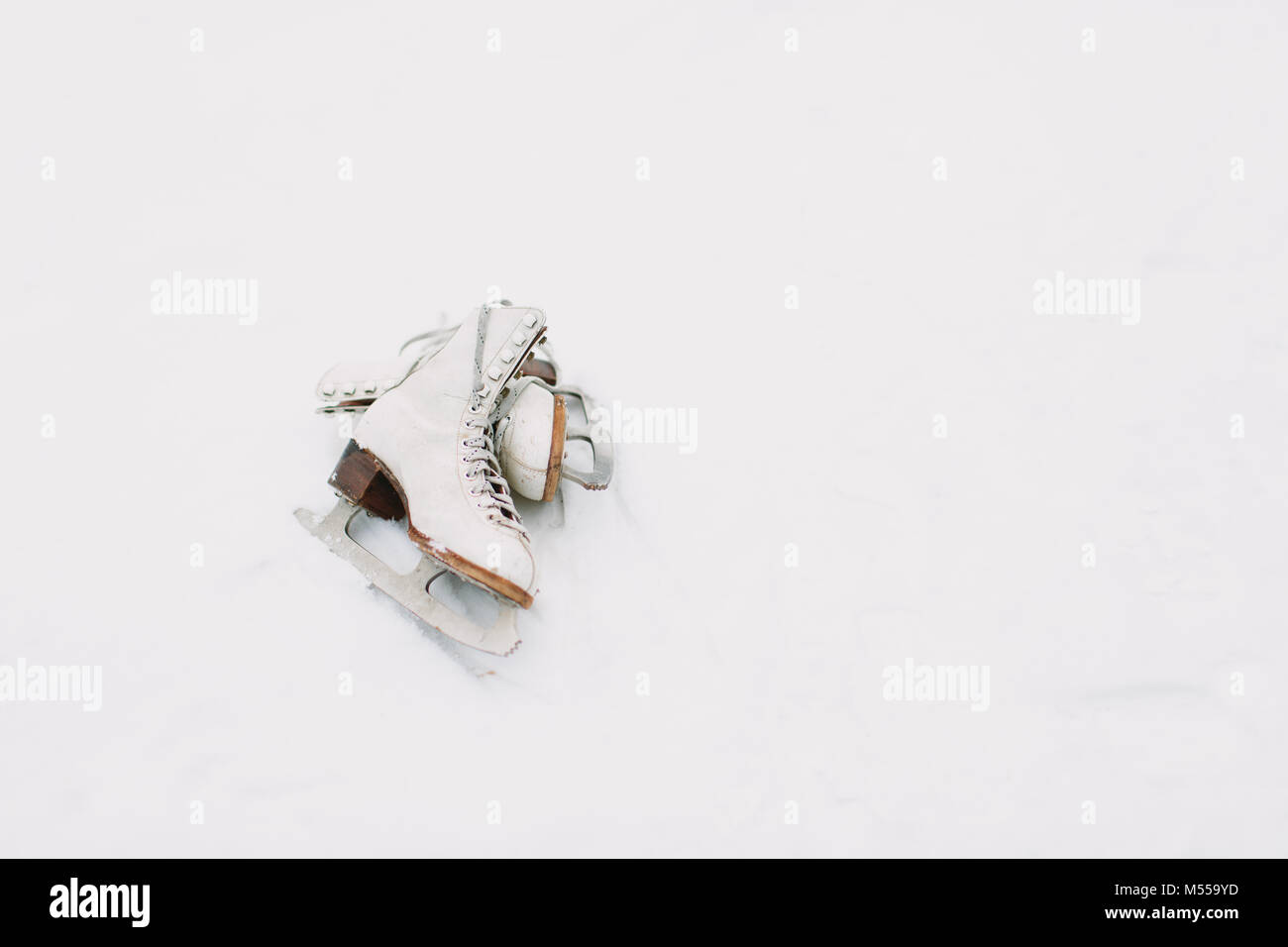 A pair of ice skates lying on snowy background Stock Photo - Alamy