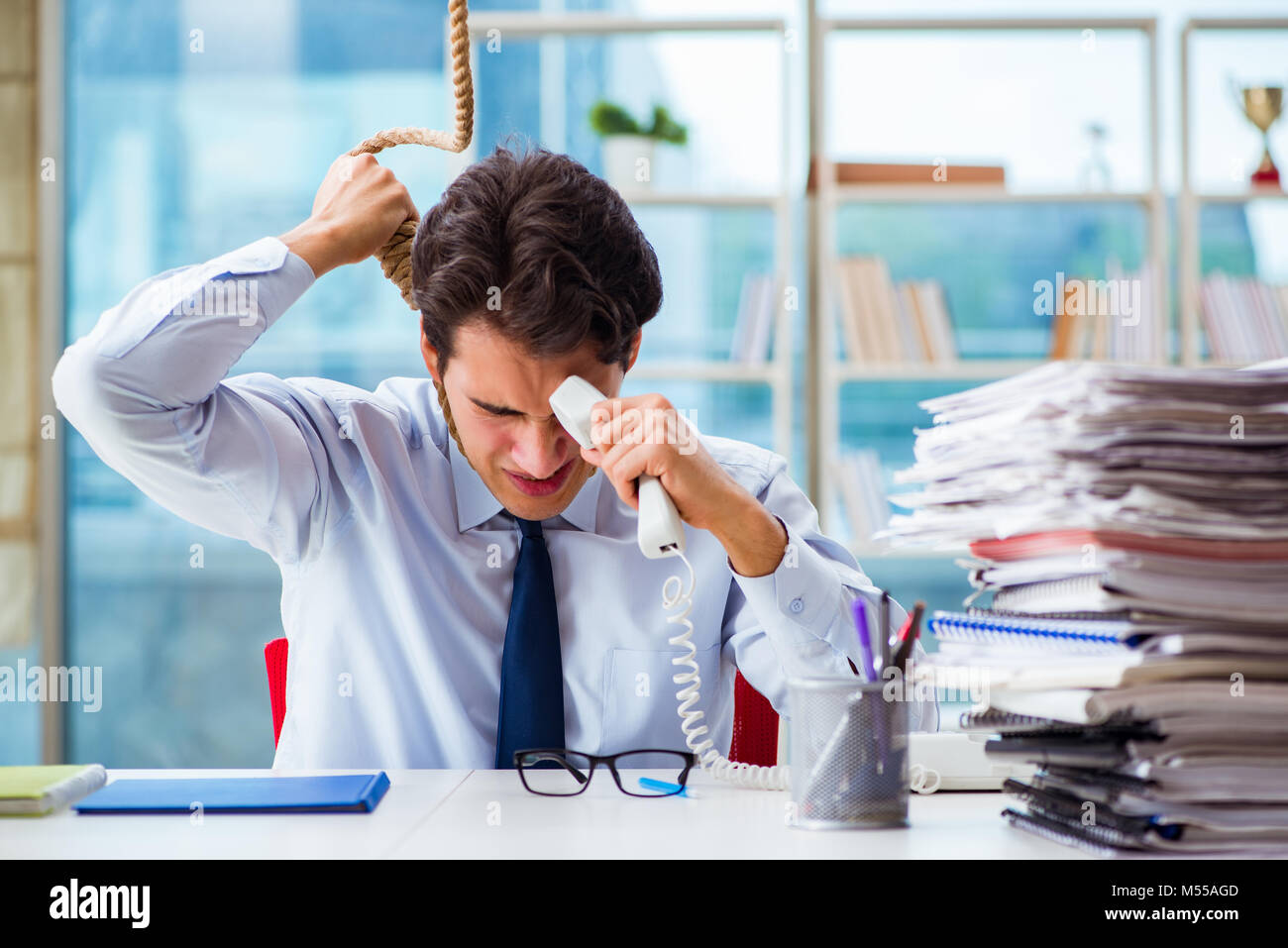 Unhappy businessman thinking of hanging himself in the office Stock ...