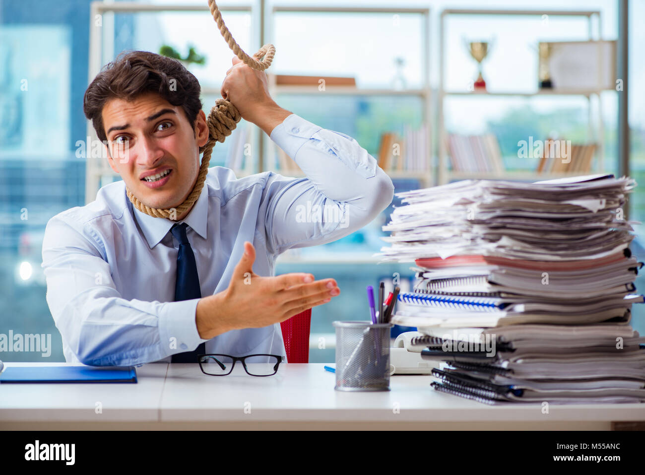 Unhappy businessman thinking of hanging himself in the office Stock ...