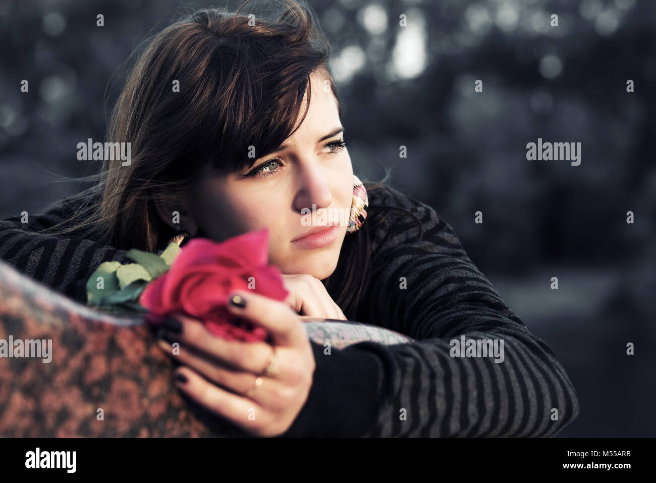 Sad young woman with a red rose Stock Photo - Alamy
