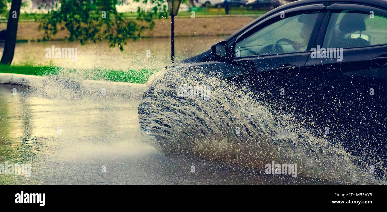 car rain puddle splashing water toning Stock Photo - Alamy