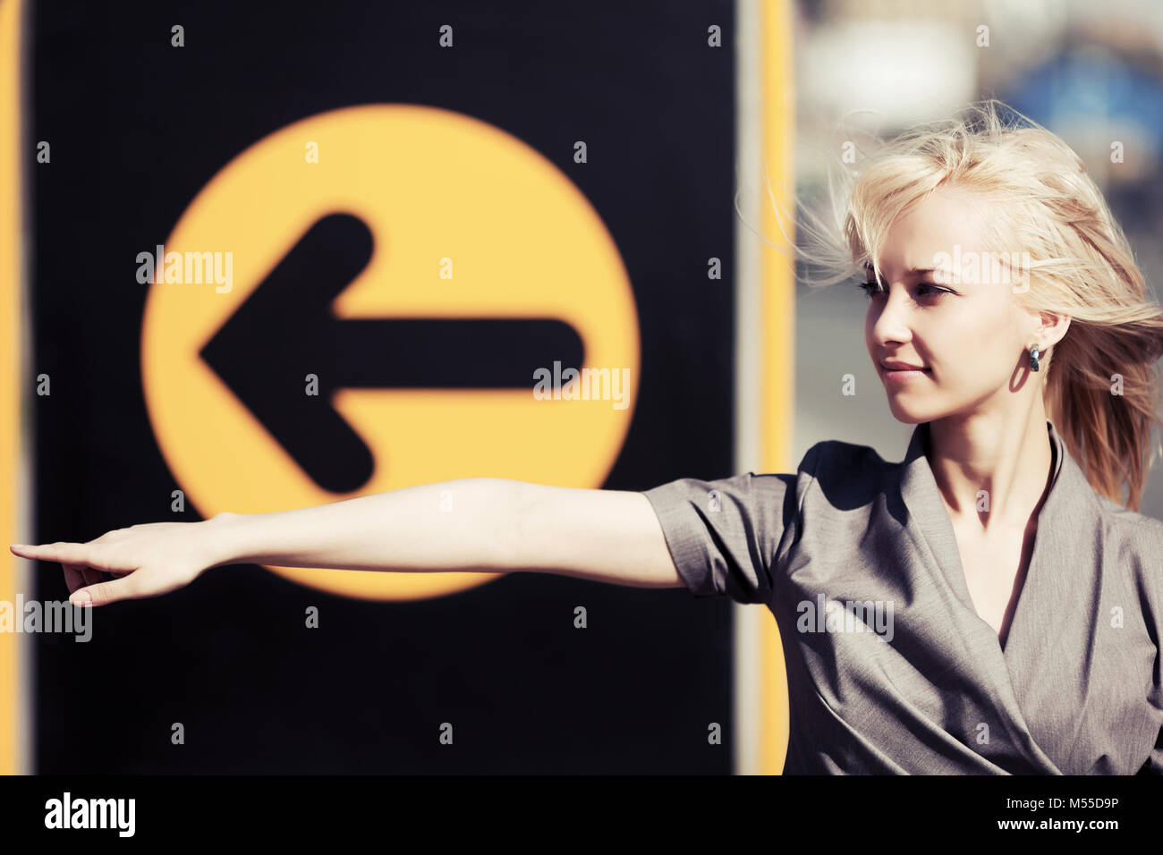 Young woman pointing a direction Stock Photo - Alamy