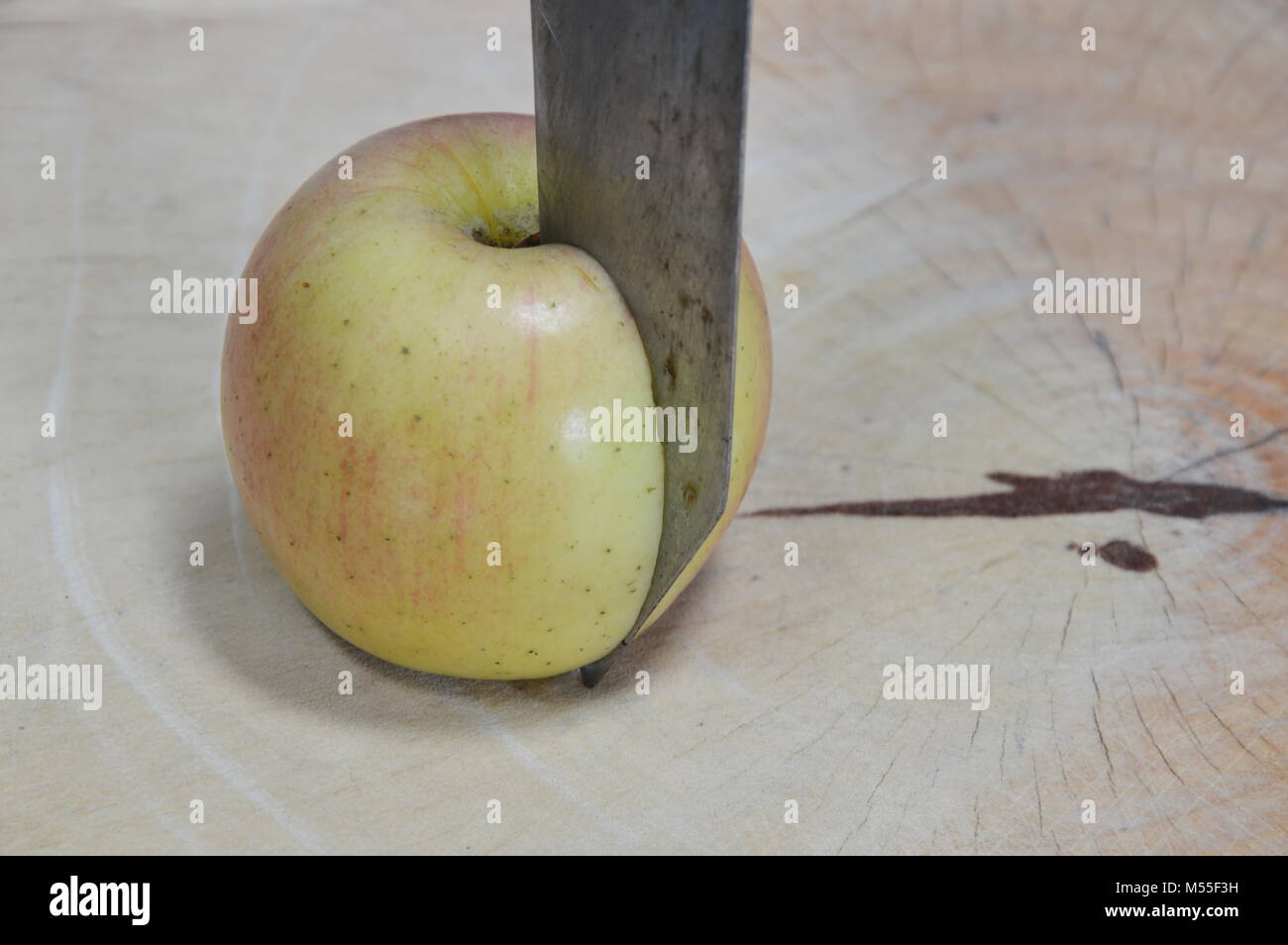 knife cut apple on wooden chop block Stock Photo - Alamy