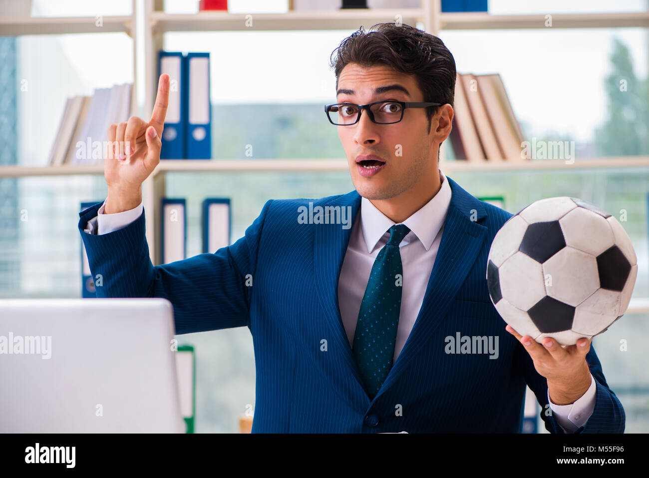 Businessman playing football in the office Stock Photo - Alamy