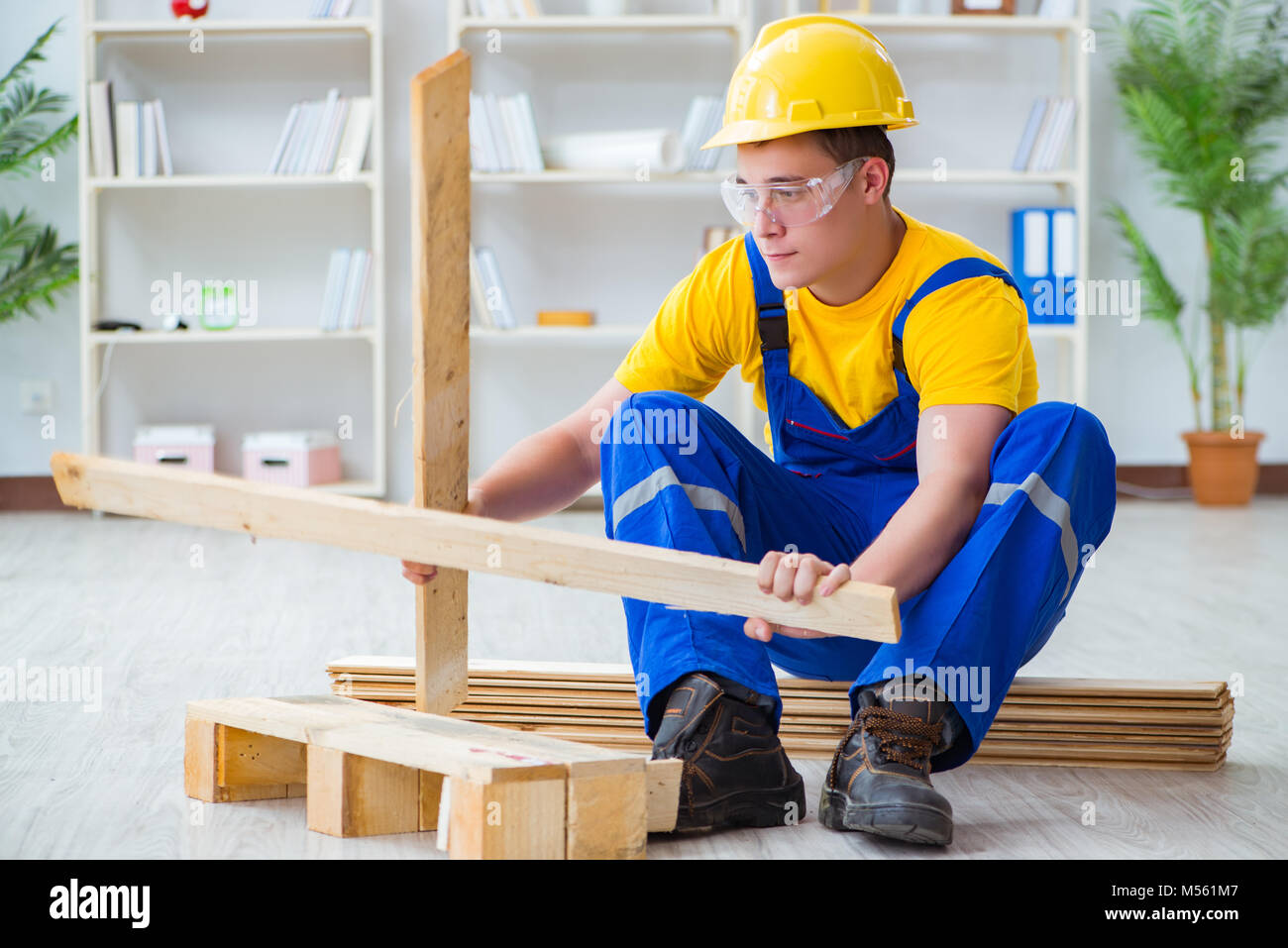 Young man assembling wood pallet Stock Photo - Alamy