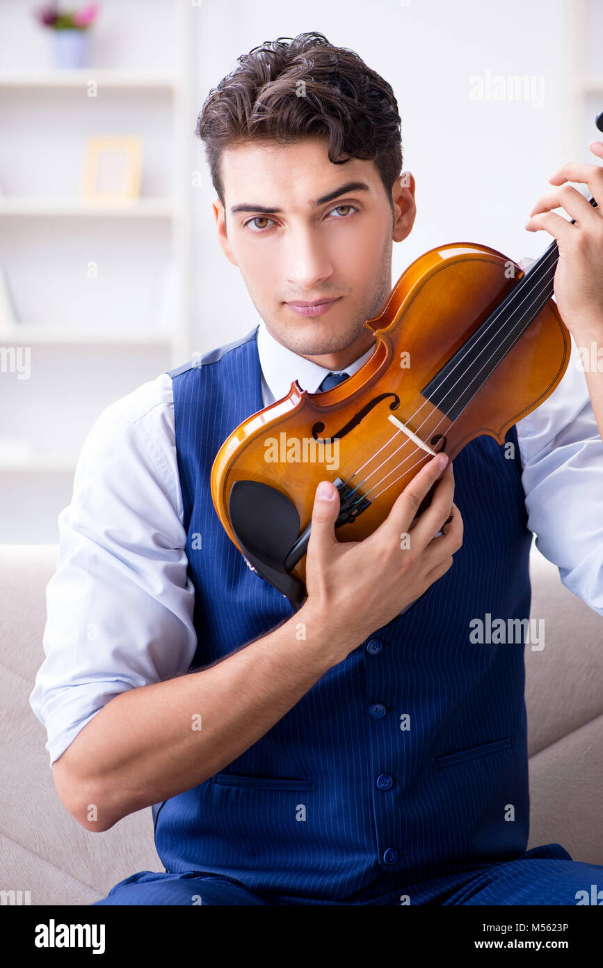 The young musician man practicing playing violin at home Stock Photo ...